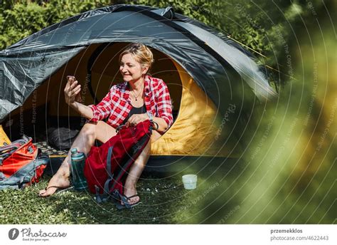 Woman Putting Up A Tent At Camping During Summer Vacation Female