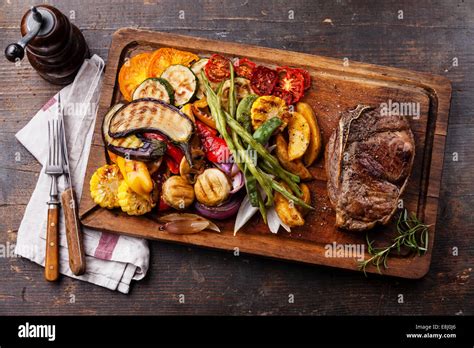 Club Beef Steak And Grilled Vegetables On Cutting Board On Dark Wooden