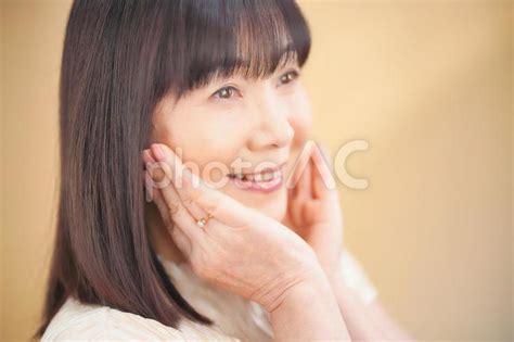両手で頬を触る女性（ベージュ背景） No 27016541｜写真素材なら「写真ac」無料（フリー）ダウンロードok