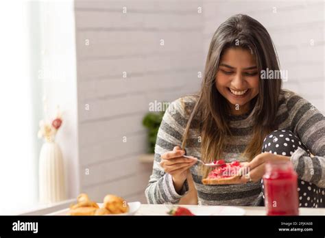 Woman Applying Fruit Jam On Bread During Breakfast Stock Photo Alamy