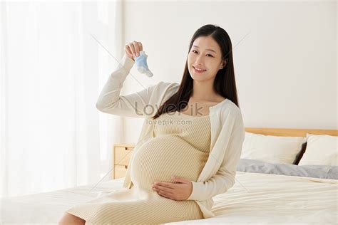 작은 양말을 들고 임신 아름다운 어머니 사진 무료 다운로드 Lovepik