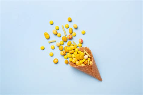 복사 공간이 있는 컬러 배경에 떨어지는 다양한 전통 사탕으로 가득 찬 와플 콘 해피 홀리데이 판매 개념 웃옷에 대한 스톡 사진