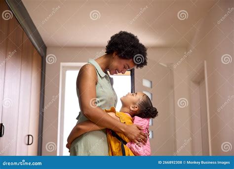 Hija En Casa Abrazando A Su Madre Mientras La Ayuda A Prepararse Para La Escuela Foto De Archivo