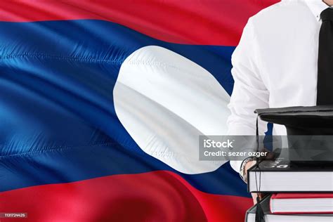 성공적인 학생 교육 개념입니다 라오스 국기 배경에 책과 졸업 모자를 들고 교사 교육 관련 직업에 대한 스톡 사진 및 기타 이미지