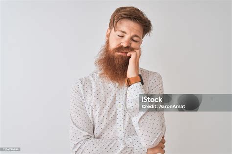 젊은 빨간 머리 아일랜드 남자 는 피곤 하 고 교차 된 팔을 가진 우울증 문제로 지루 해 보이는 고립 된 흰색 배경 위에 서
