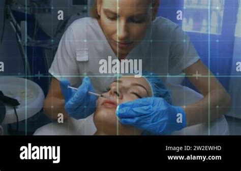 Animation Of Green Grid Moving Over Female Nurse Injecting Female