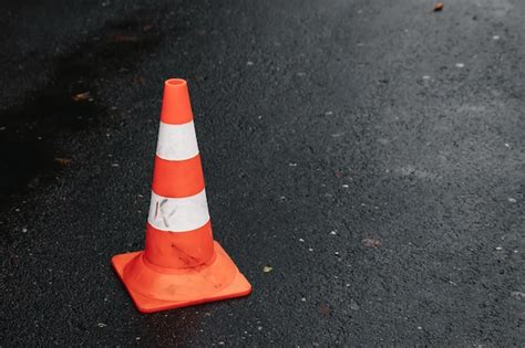 Premium Photo Traffic Cone With White And Orange Stripes On Gray Asphalt