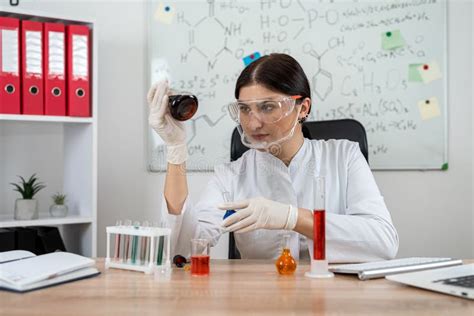 Female Scientific Laboratory Looking On Test Tube With Reagent For Experiment Stock Image