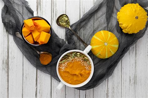 어두운 회색 직물을 사용하여 흰색 나무 배경에 세라믹 접시에 호박 크림 수프 작은 장식 호박 냄비와 숟가락 0명에 대한 스톡 사진 및 기타 이미지 Istock