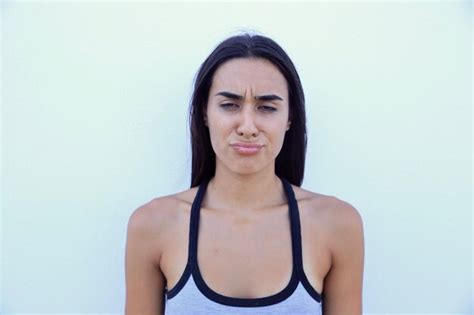 Premium Photo Young Woman Sitting Against Wall