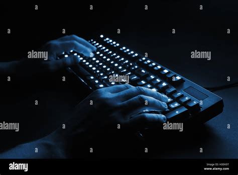 Illuminated Keyboard Male Hands Typing On A Computer Hacker Or Programmer At Work On A Black