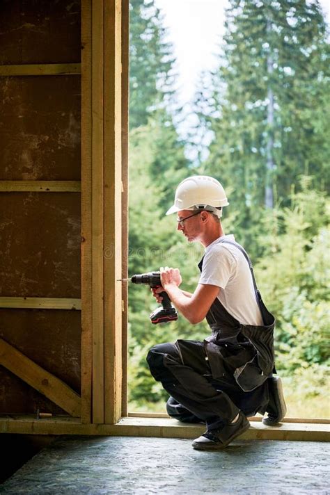 Carpenter Working With Screwdriver While Constructing Wooden Framed