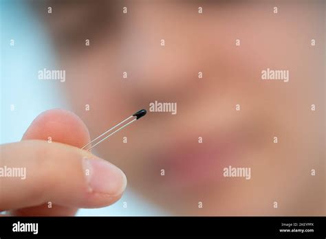 Young Woman Holds A Thermistor In Her Hands A Semiconductor Element For
