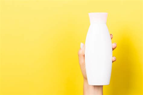 모방 공간으로 노란 배경에 화장품 제품 한 병을 들고 여자의 손을 닫습니다 개념에 대한 스톡 사진 및 기타 이미지 개념