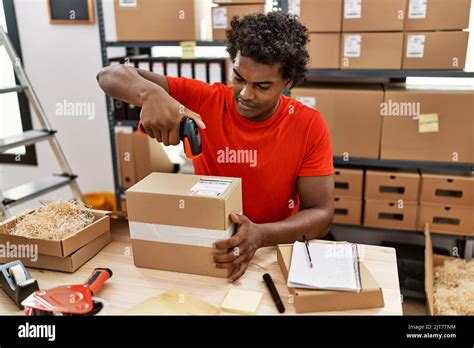 Young South East Man Using Barcode Reader Device Working At Storehouse
