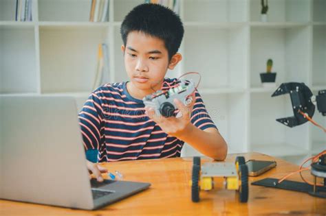 Asian Boy Learning And Studying The Work Of Technology Robots