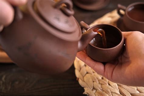 다도 전통적인 아시아 차 도구 정통 세트를 제공합니다 갈색 도자기 찻주전자에서 찻잔까지 차를 따르는 사람 대나무 쟁반 생활방식 웰빙 균형 건강 차 양조 장비 Pu Erh에