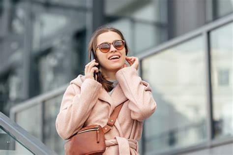 회색 도시 도시 배경에 스마트 한 야외 이야기를하는 분홍색 드레스를 입은 여성 Brand Name Smart Phone에 대한