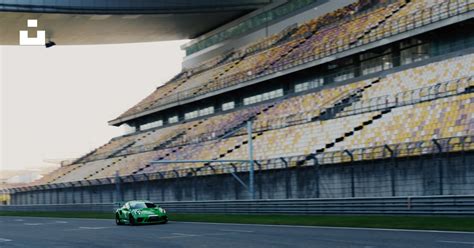 대형 경기장 옆 트랙에서 운전하는 녹색 경주 용 자동차 사진 Unsplash의 무료 포르쉐 이미지