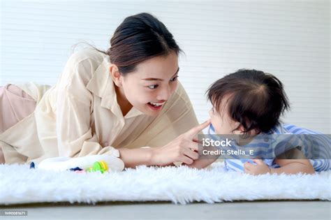 행복한 유아 아기 아이와 어머니는 거실의 푹신한 흰색 깔개 바닥에 앉아 있고 어린 소녀 딸과 엄마는 함께 장난감을 가지고 놀고