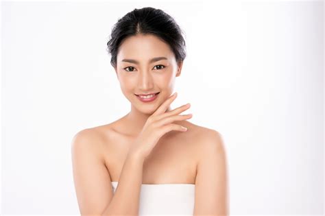 아름다운 젊은 아시아 여자는 흰색 배경 뷰티 화장품과 얼굴 치료 개념에 고립 된 신선한 건강한 피부로 그녀의 깨끗한 얼굴을