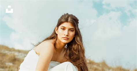 낮에 갈색 바위에 앉아 있는 흰색 민소매 드레스를 입은 여자 사진 Unsplash의 무료 여자 이미지