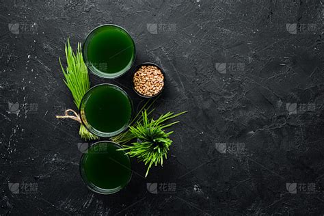 从绿色的小麦和麦粒发芽的果汁在黑色的背景上微绿色健康食品前视图为你的文本留出空间