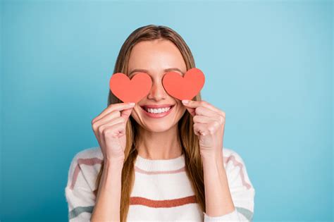才能のあるはがきで彼女の目を覆う魅力的なかわいいかわいいかわいいかわいいガールフレンドの写真を閉じる心笑顔歯の孤立したパステルブルーの背景