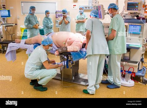 Operating Theatre Team Preparing An Obese Female Patient Prior To