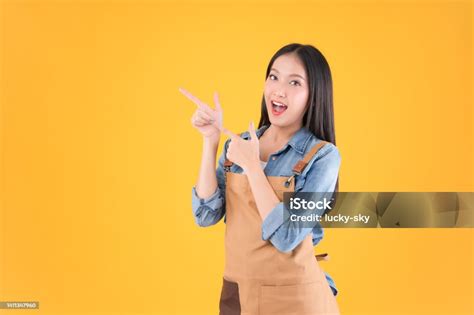 예쁜 아시아 여성 스마일 커피 프리랜서 자신의 커피 바 숍은 커피 종이 컵을 들고 자신의 상점 노란색 배경에서 신용 카드를 스 와이프하는 단말기 돈을 통해 신용 카드로