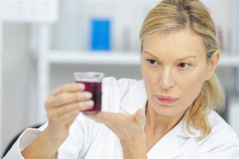 Female Senior Looking At Flask Indoors Stock Image Image Of
