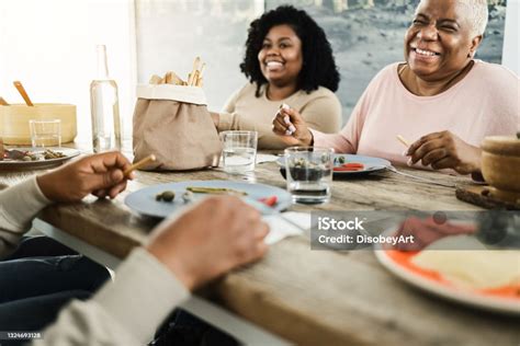 집에서 점심을 먹는 행복한 흑인 가족 아버지 딸 아들과 어머니가 저녁 식사 테이블에 함께 앉아 즐거운 엄마 얼굴에 주요 초점 3