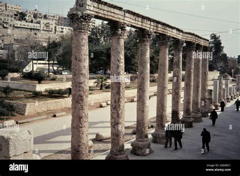 People Pass A Row Of Columns On A Street In Front Of The Theatre In