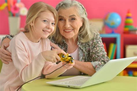 Abuelita Con Su Nieta Jugando A Juegos De Ordenador Imagen De Archivo