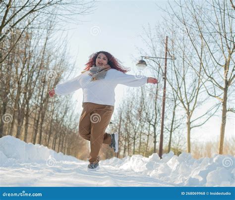 Smiling Chubby Redhead Woman Running In Park In Winter Stock Photo