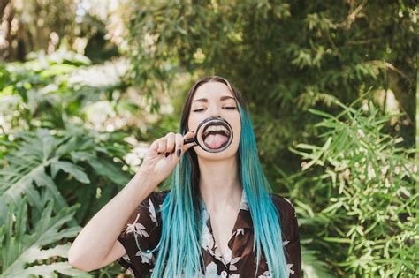 Free Photo Young Woman Standing In Front Of Plants Showing Tongue