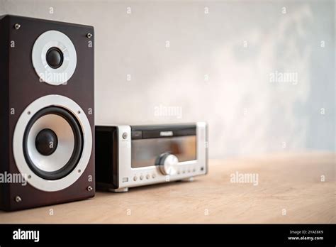 Stylish Audio Setup Featuring A Sleek Speaker And Modern Stereo System On A Wooden Surface In A