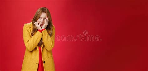 Portrait Of Shocked And Scared Insecure Woman In Yellow Coat Covering
