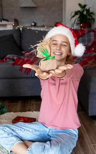 산타 모자를 쓴 귀여운 여고생이 크리스마스 선물에 활짝 웃고 진심으로 기뻐합니다 새해 연휴 행복 및 가족 전통의 개념 10 11세에 대한 스톡 사진 및 기타 이미지 Istock