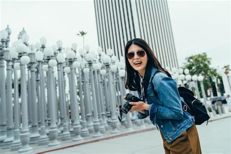 Premium Photo Dutch Angle Shot Korean Woman Holding Digital Camera Is Laughing Heartily In