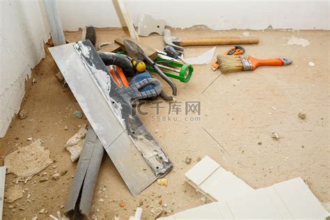 维修工作期间，施工和维修工具位于混凝土地板上，包括抹刀、锤子、卷尺。高清摄影大图 千库网