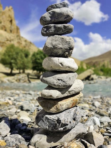 Premium Photo Pile Of Small Rocks With A Mountain And A Lake In The