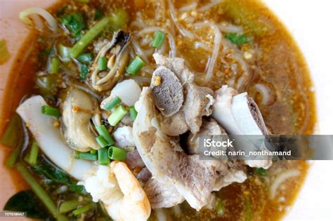 돼지 뼈 가재 새우와 매운 해산물 국수 수프 나무 테이블 배경에 분홍색 그릇에 아시아 음식입니다 태국 스타일의 국수와 태국의 길거리 음식 맨 위 보기 건강한 생활방식에 대한