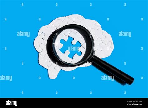 Gros plan d une loupe sur des pièces de puzzle ressemblant à un cerveau