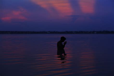 Un devoto hindú realiza rituales nocturnos mientras toma un baño sagrado en el río Ganges en