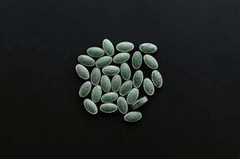 검은 색 어두운 배경에 엽록소 정제 플랫 레이 식이 보조 제 건강 지원 및 치료 생물학적 활성 첨가제 해독 약 0명에 대한 스톡