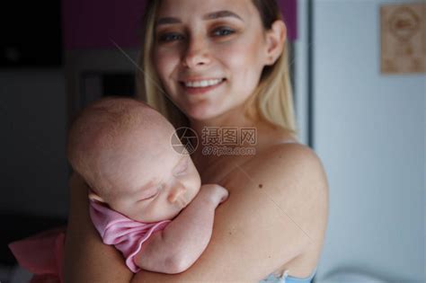 年轻漂亮的女人妈抱着她两个月大的女儿微笑着孕产妇保健母乳喂养和幸高清图片下载 正版图片505638882 摄图网