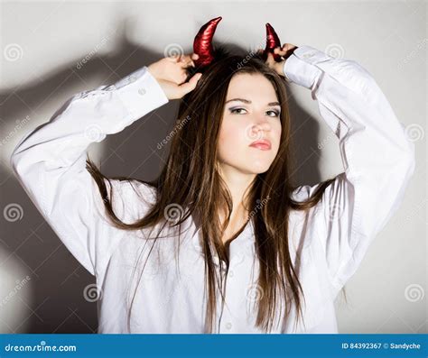 Young Girl In A Man`s White Shirt With Red Horns Looks Like Pretty