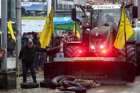 A Man Holds A Tire During A Protest Of European Farmers Over Price
