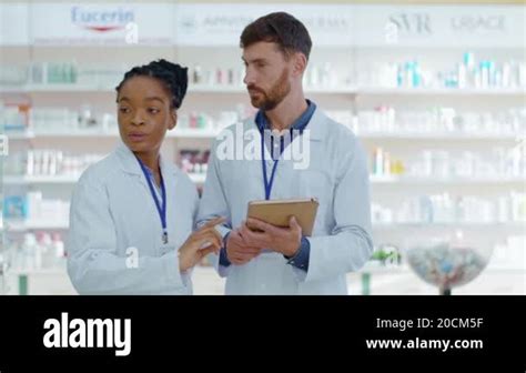 Multi Ethnic Couple Of Pharmacists Collecting Data Medication Treatment